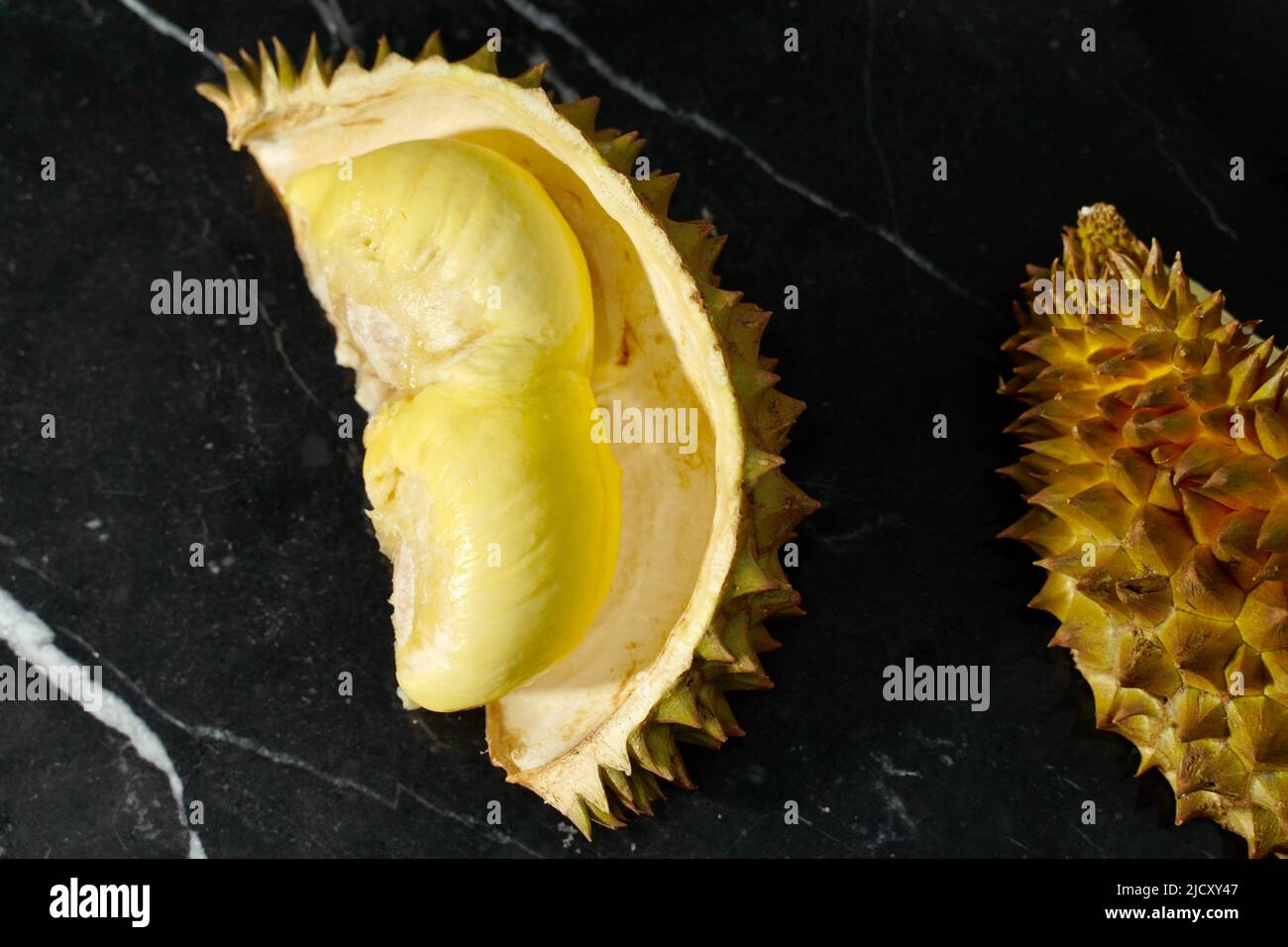 Fresh durian in packaging on white dish with durian peel on banner ...