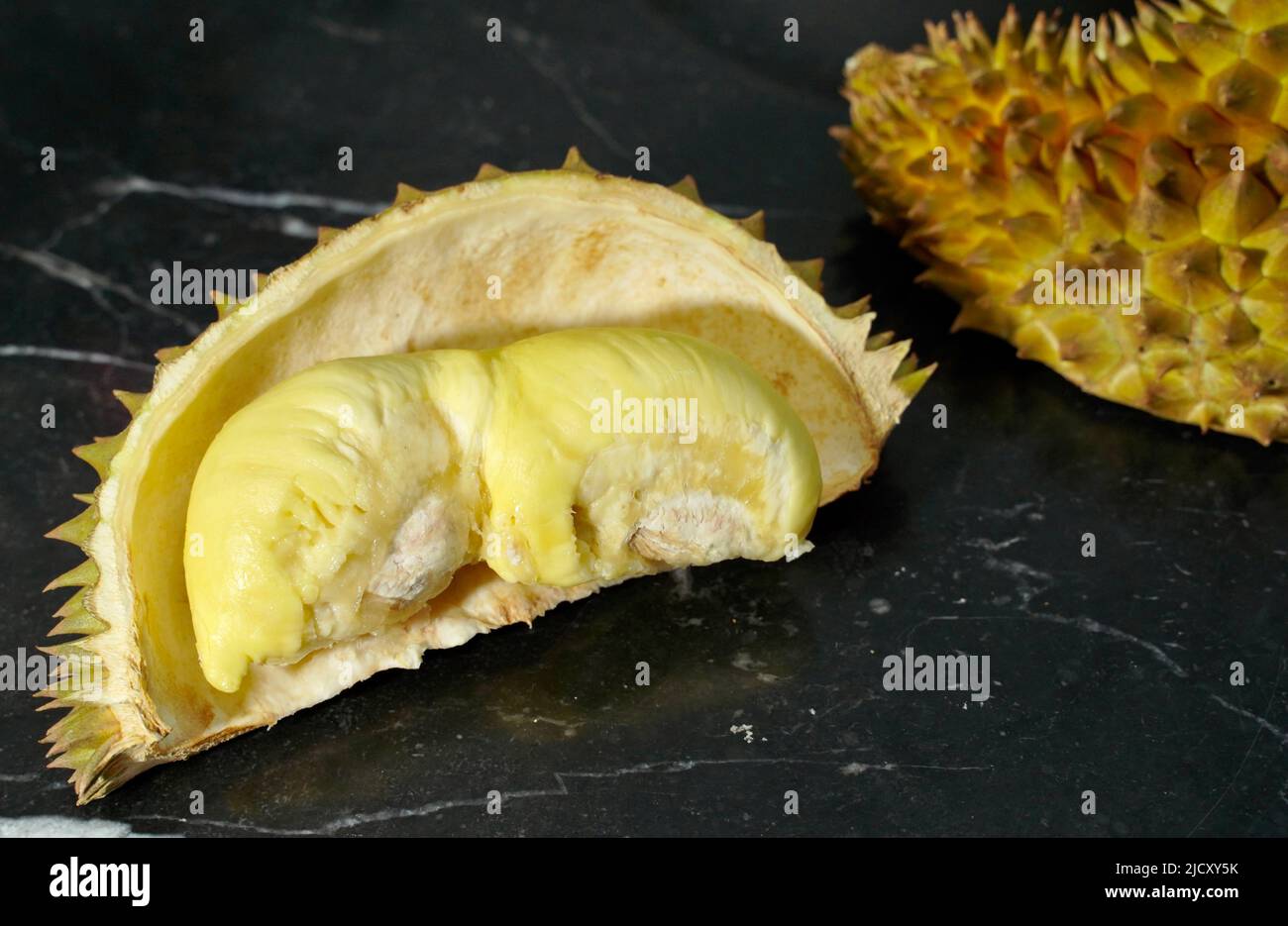 Fresh durian in packaging on white dish with durian peel on banner ...