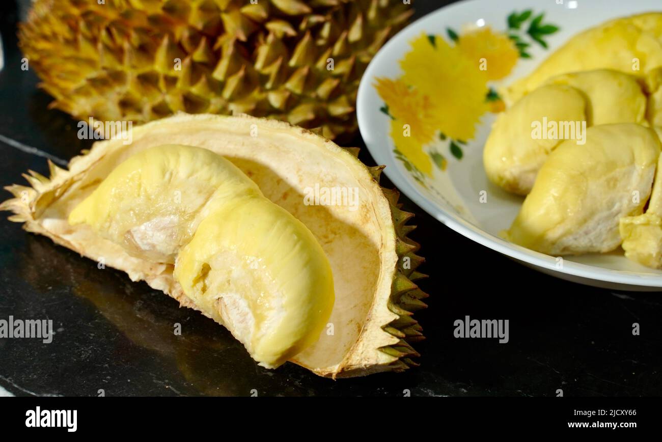 Fresh durian in packaging on white dish with durian peel on banner ...