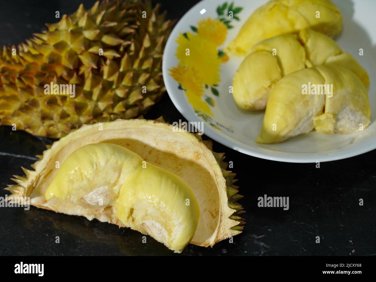 Fresh durian in packaging on white dish with durian peel on banner ...