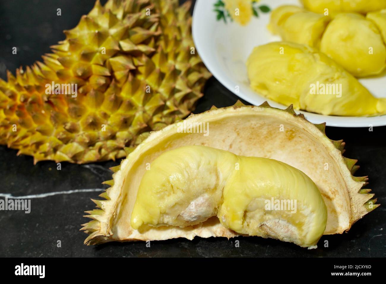 Fresh durian in packaging on white dish with durian peel on banner ...