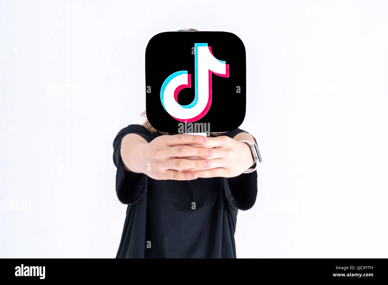 caucasian teenager holding a tiktok logo picture in his hands on a ...