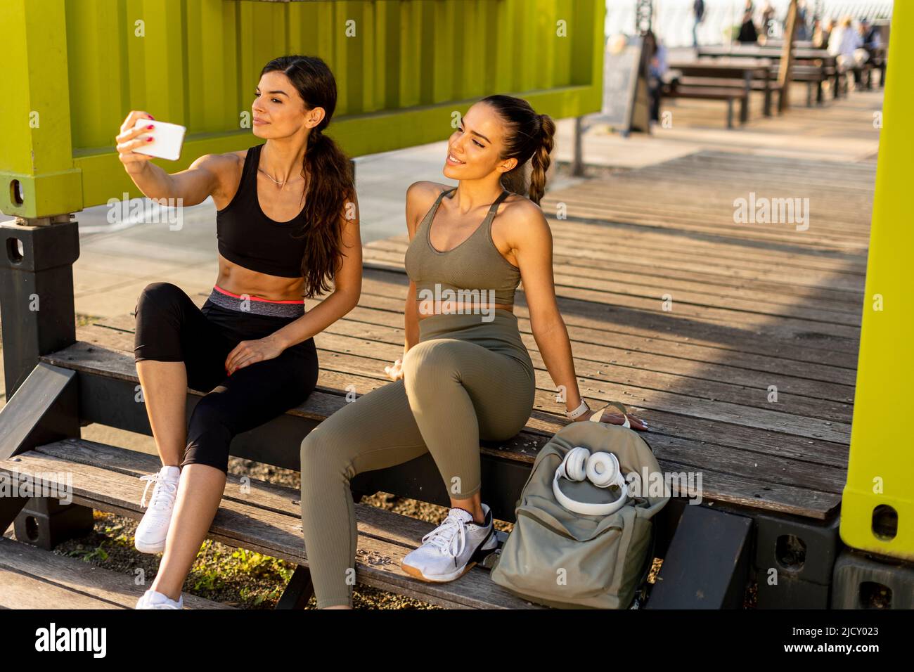 Pretty young women in sportswear taking selfie with mobile phone after ...