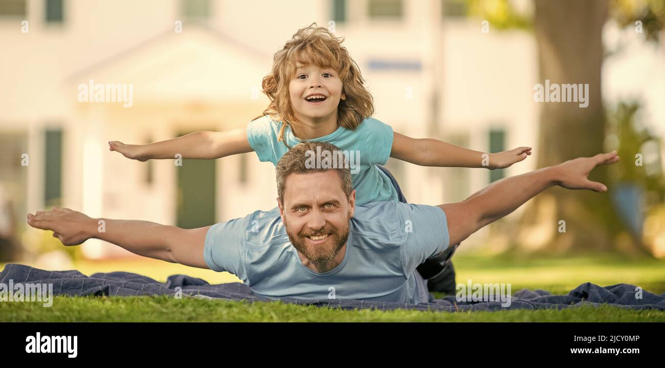 extremely happy father with kid relax together on green park grass ...