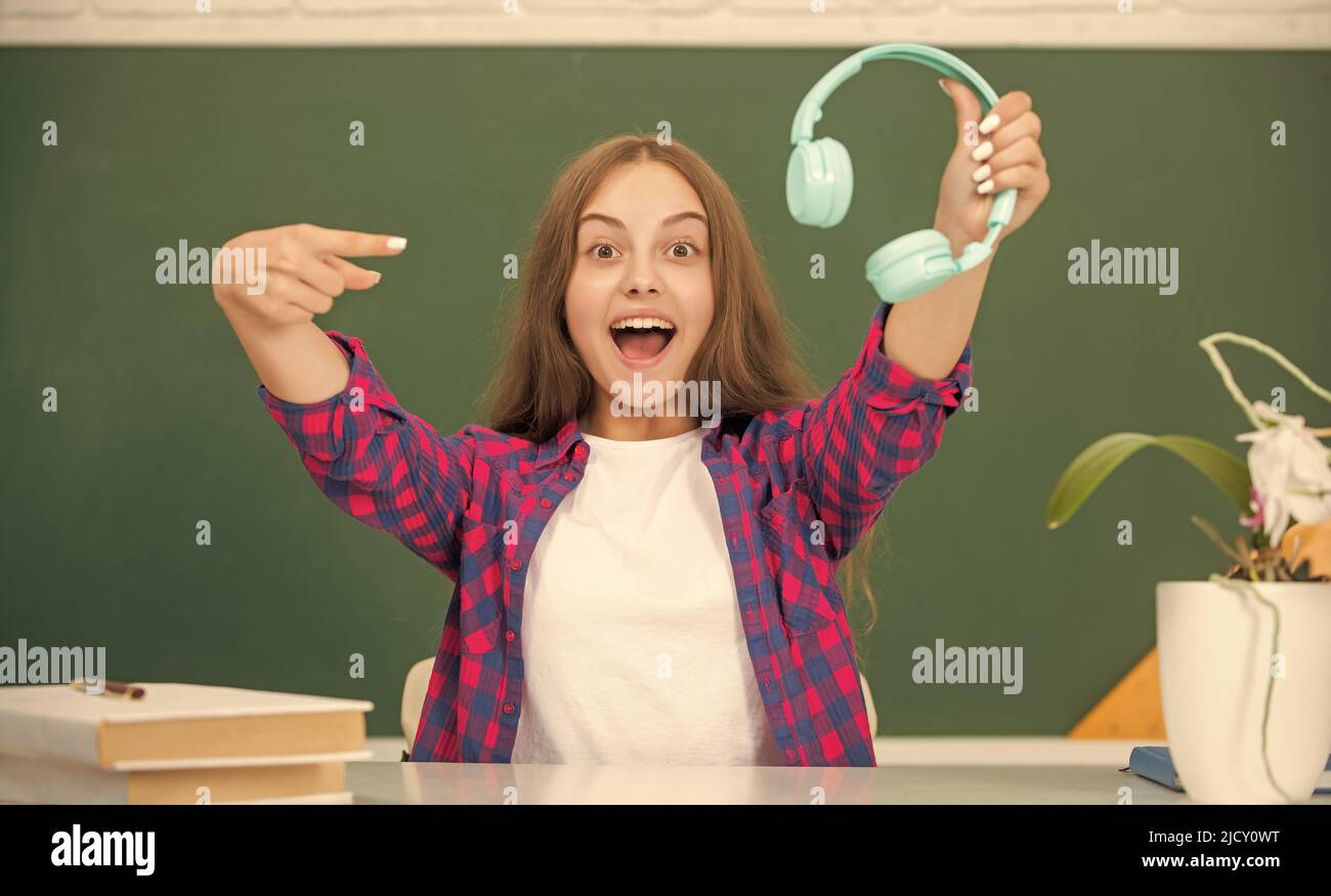 amazed child pointing finger on headphones at blackboard, childhood ...