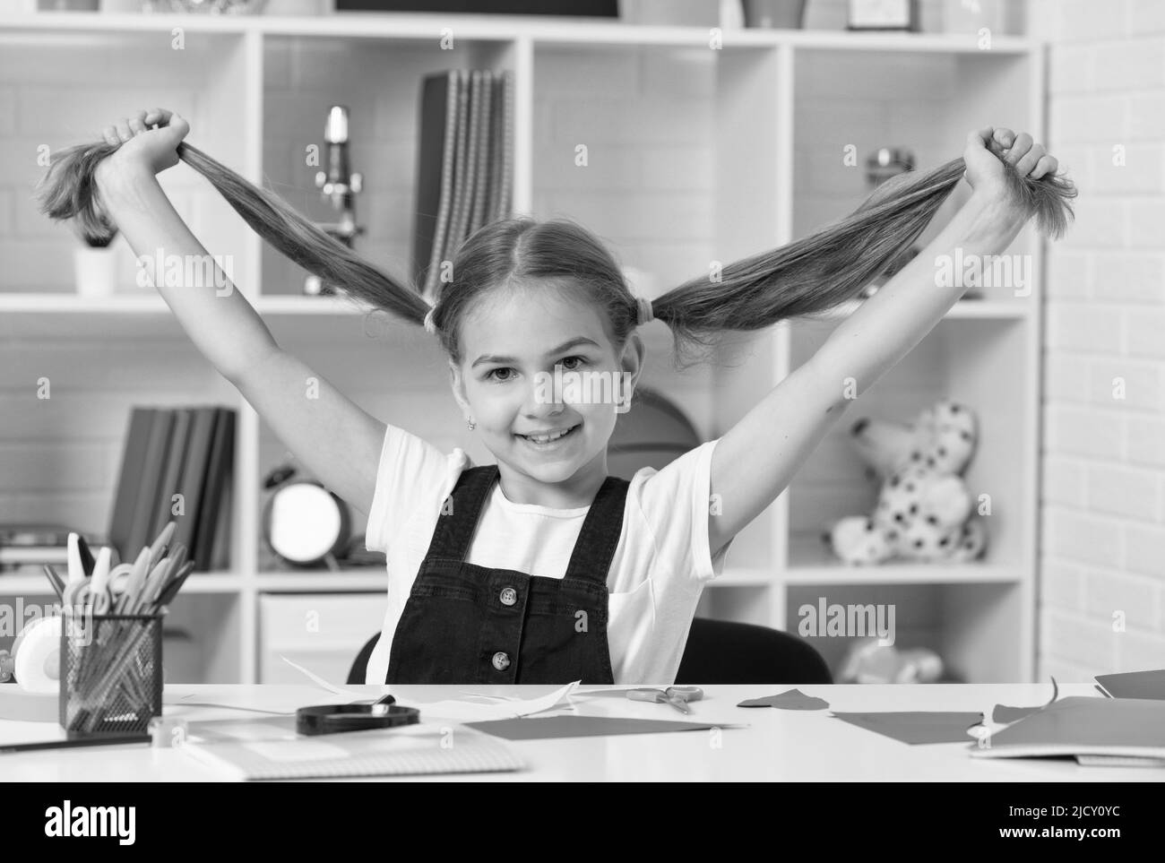 happy kid having fun with long hair pony tail at school lesson in ...