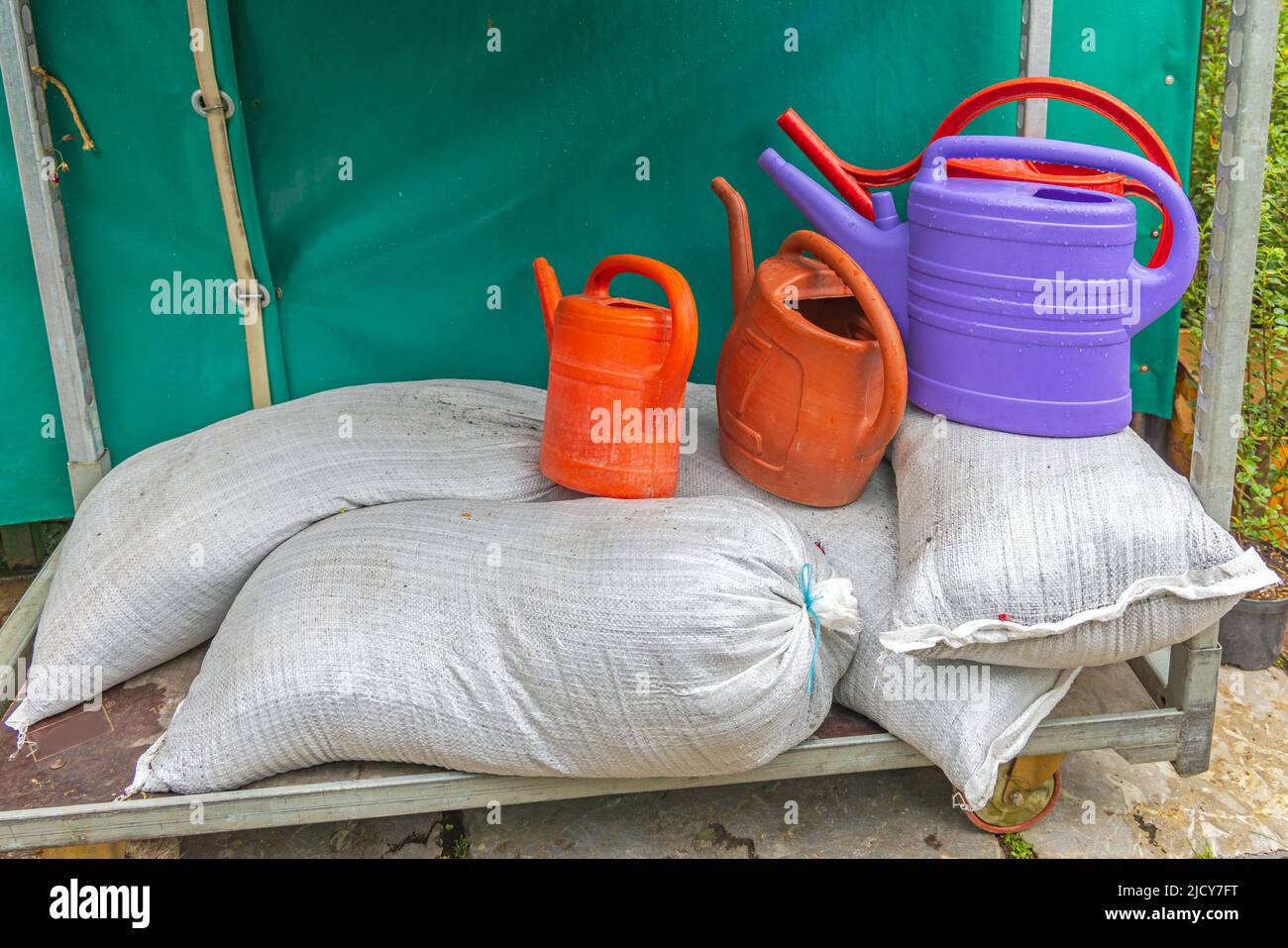 Watering Bucket Sprinkling Can at Sacks of Potting Soil Stock Photo - Alamy
