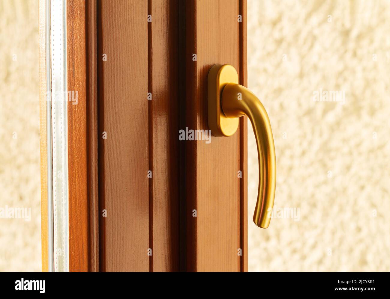 Metal window handle in golden color close-up Stock Photo - Alamy