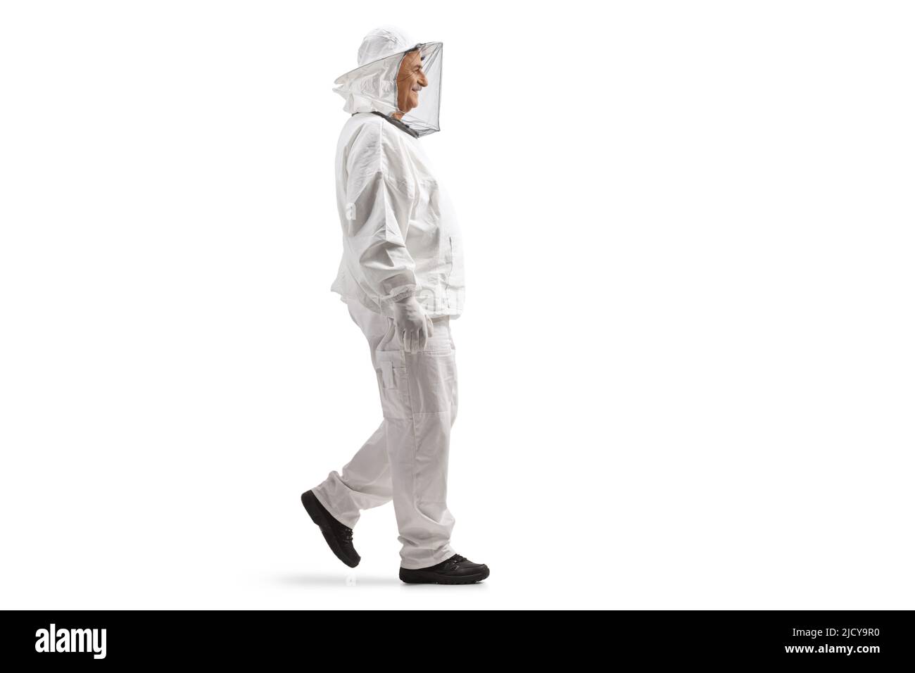 Full length profile shot of a male bee keeper in a uniform walking ...