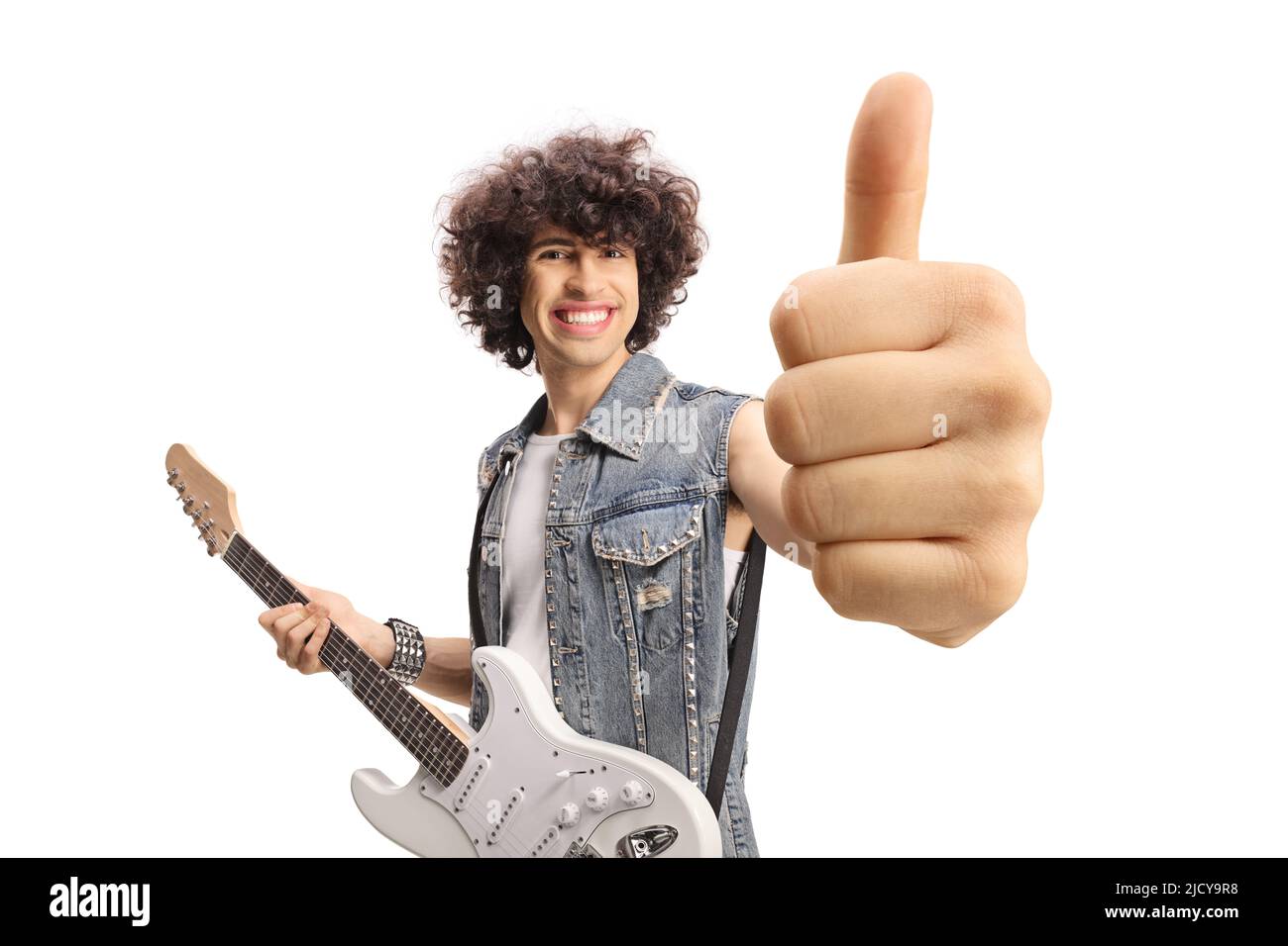 Smiling young male in a denim vest with an electric guitar showing ...