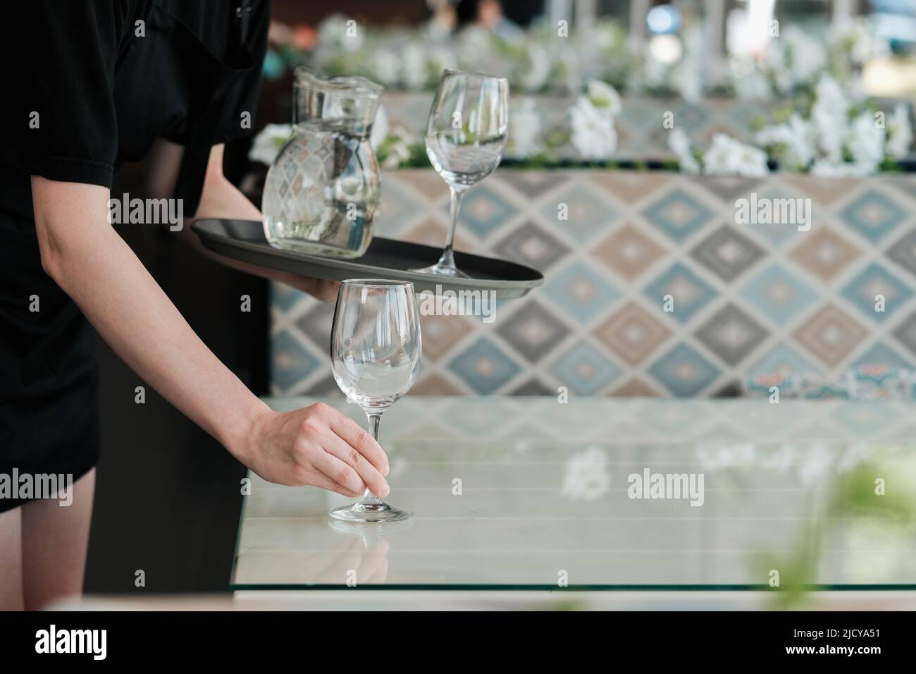 Female Waiter Serving Table with Water Glass for the Guest in ...