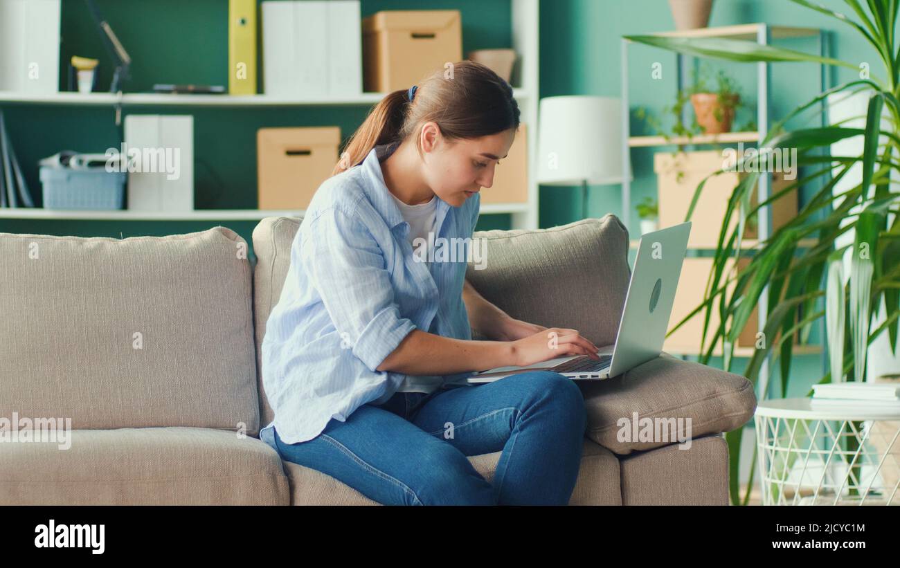 Freelancer Sitting on the Sofa Working Remotely From Home Feeling ...