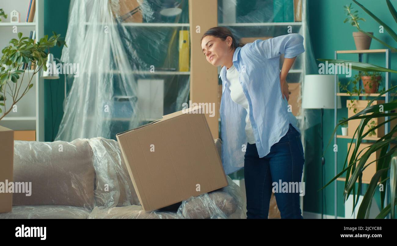 Woman Feels Sudden Back Pain When Trying to Lift a Carton Box. Woman ...