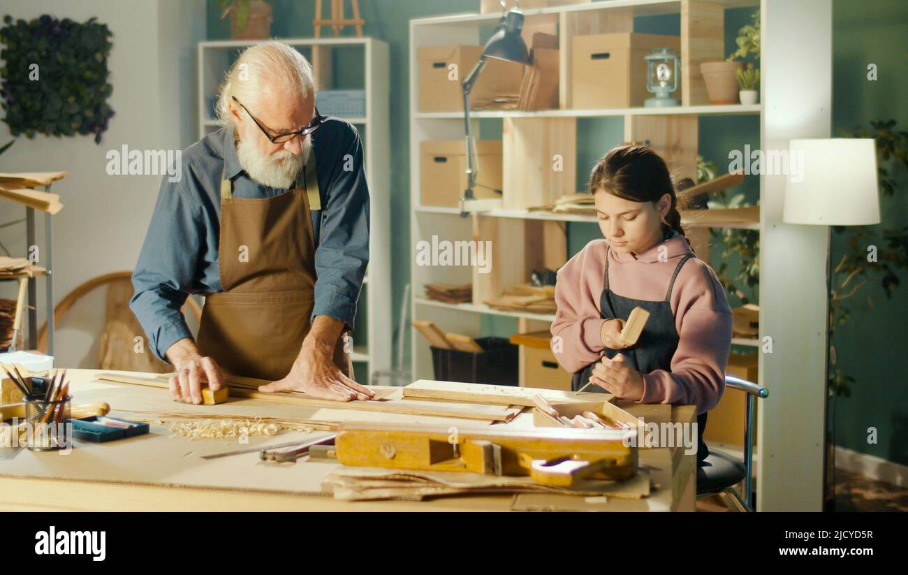 Grandfather Carpenter with his Teenage Granddaughter Works in the ...