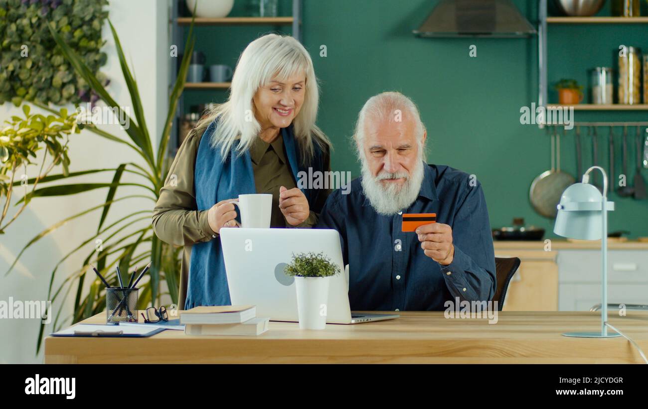 Happy older couple using computer tablet together at home hi-res stock ...