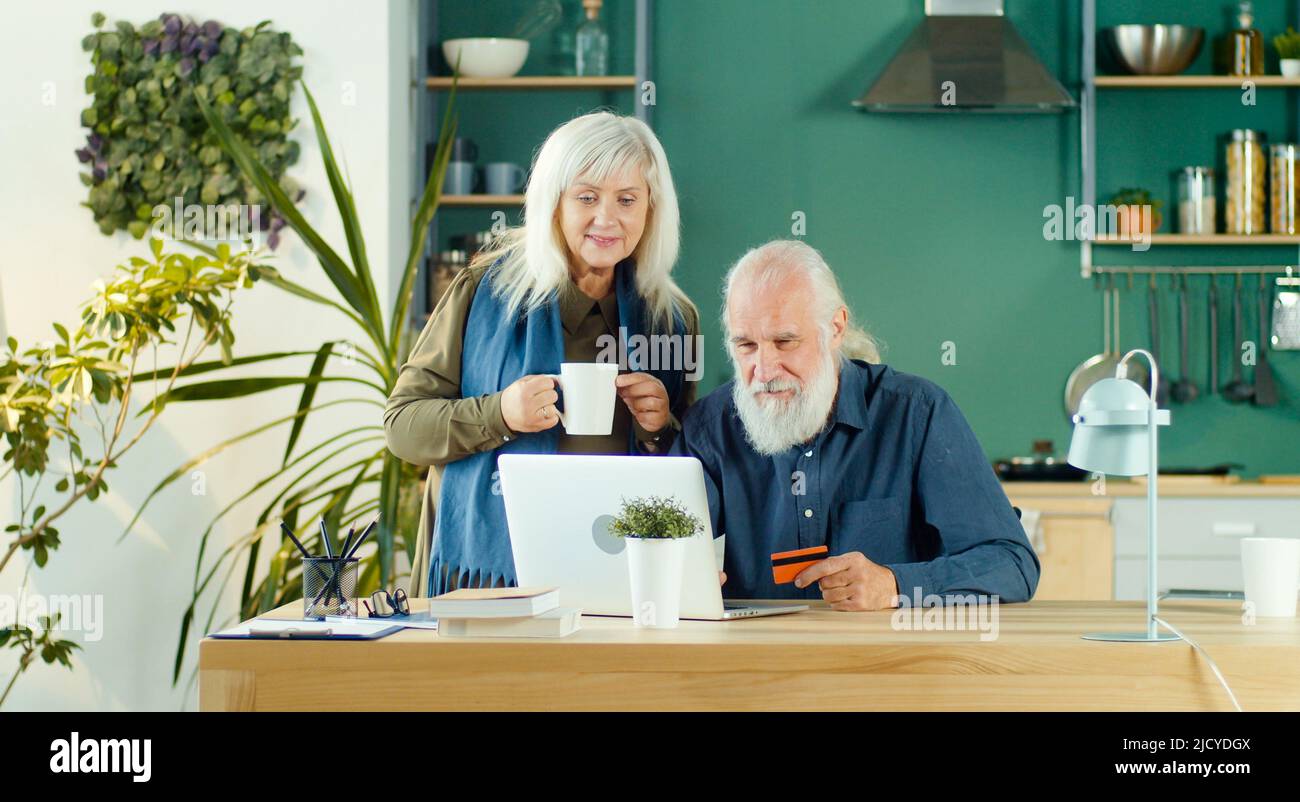 Happy older couple using computer tablet together at home hi-res stock ...