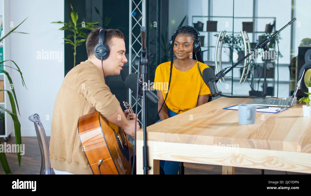 An Influential Musician Sings and Plays the Guitar During a Radio ...