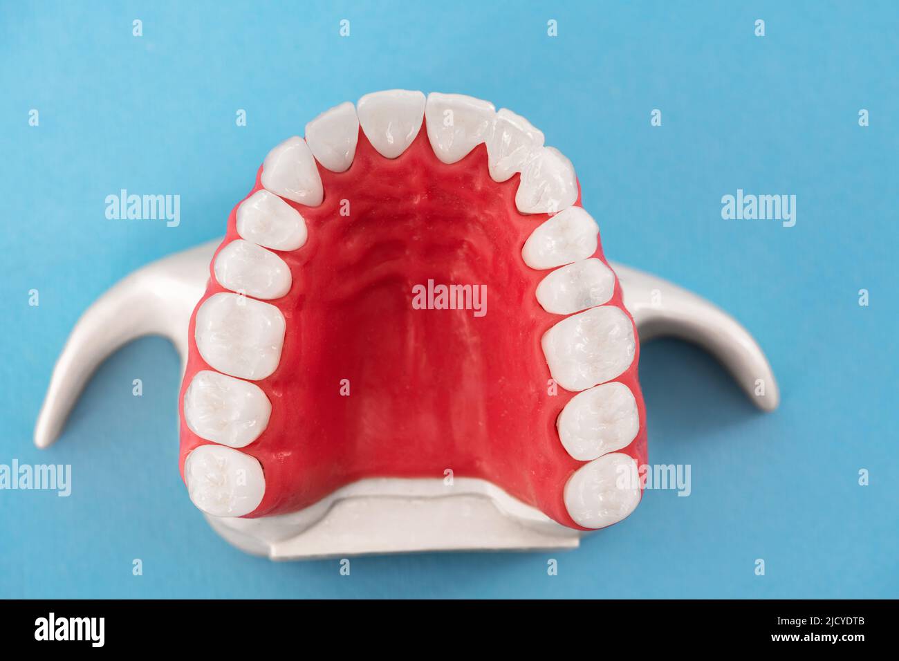Teeth implant and crown installation process parts isolated on a blue ...