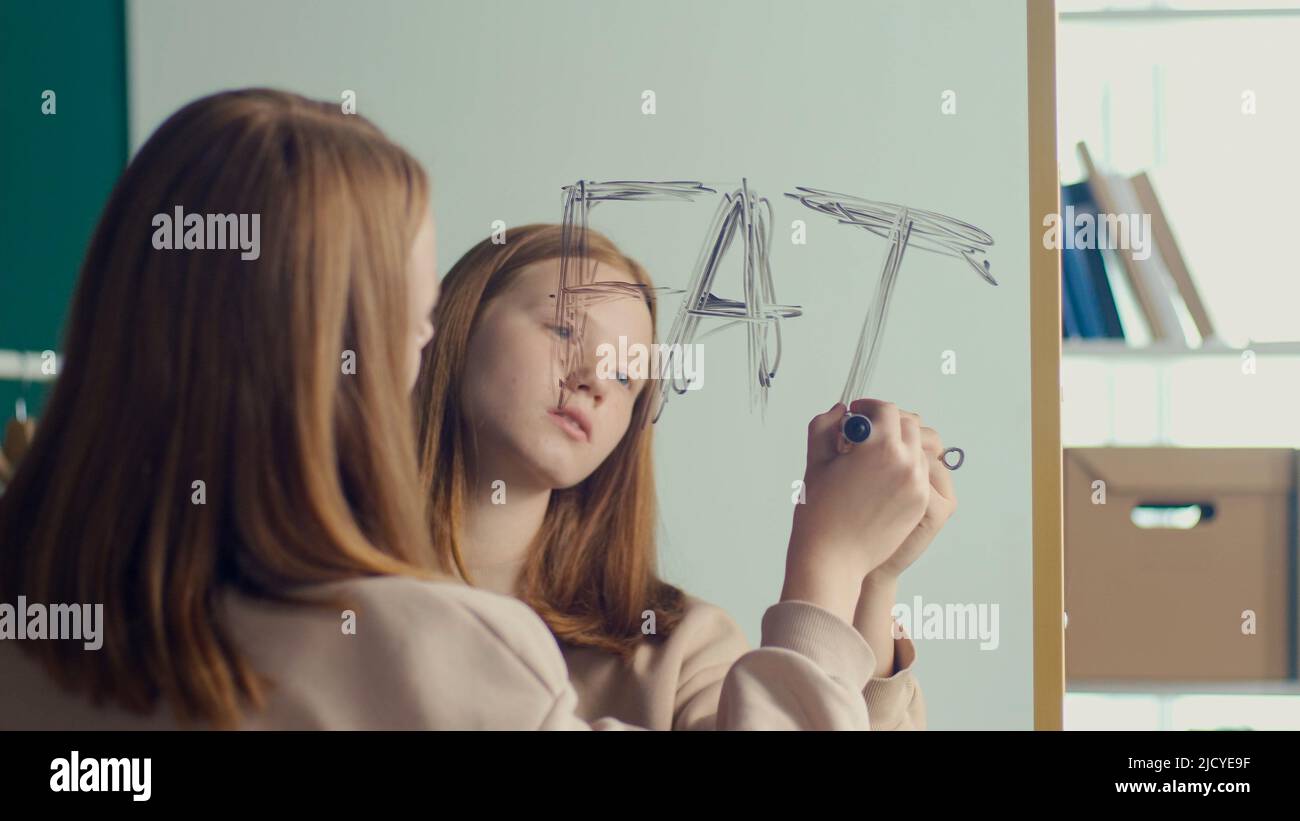 Reflection of a Red haired Teenage Girl Writing an Inscription on a ...