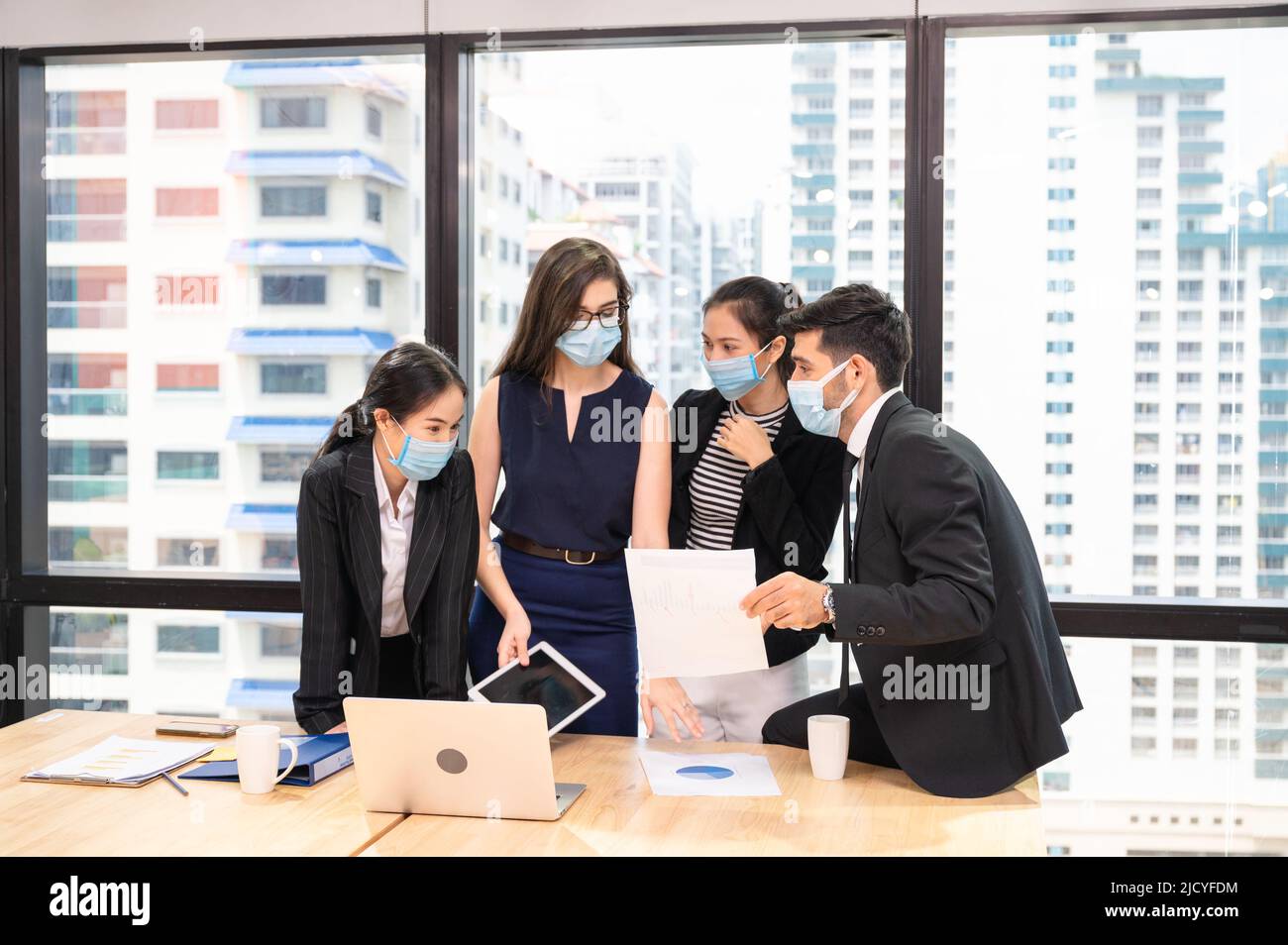 Multiethnic business team wearing face mask during business meeting in ...