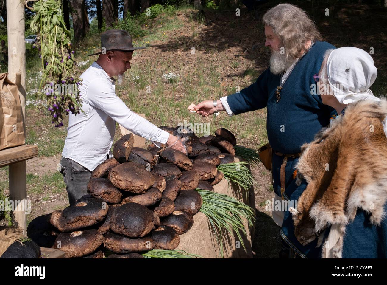 Men in Latvian folk costume buying local bread at The Ethnographic Open ...