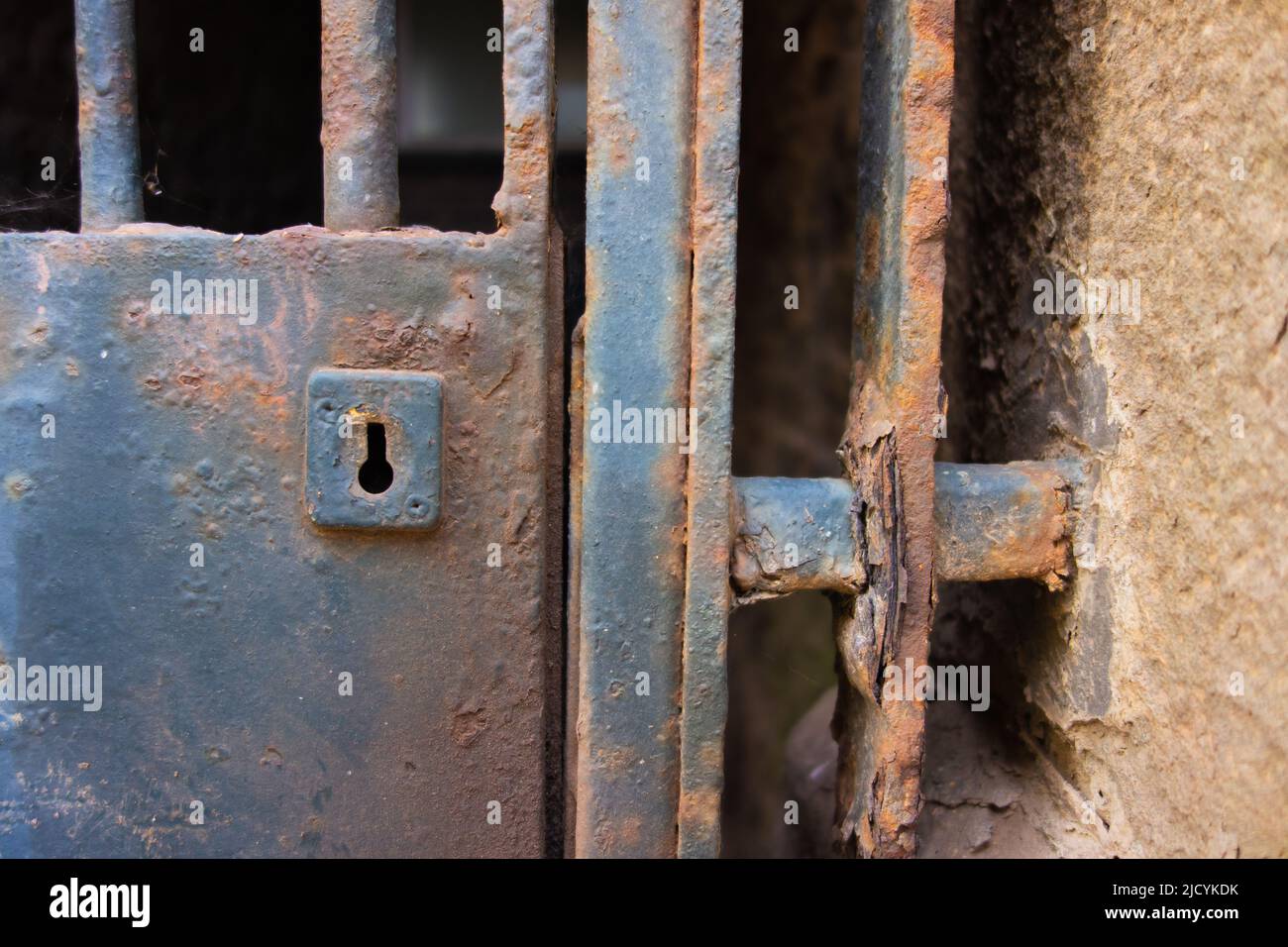 close up of a blue painted iron gate and lock with a traditional stone ...