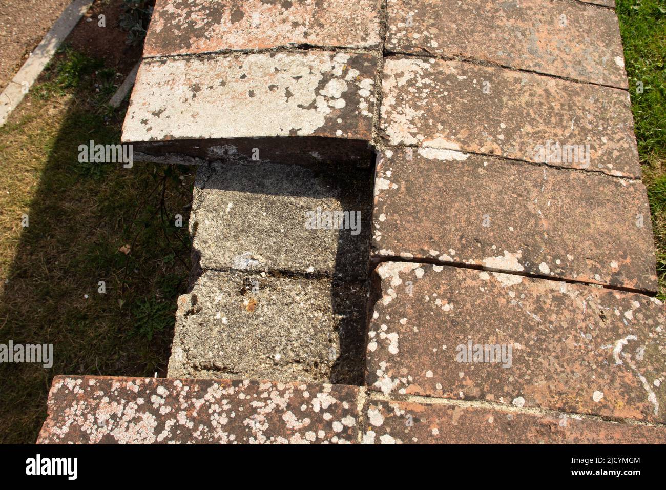 old brick work covered in lichen on top of a wall with missing and ...