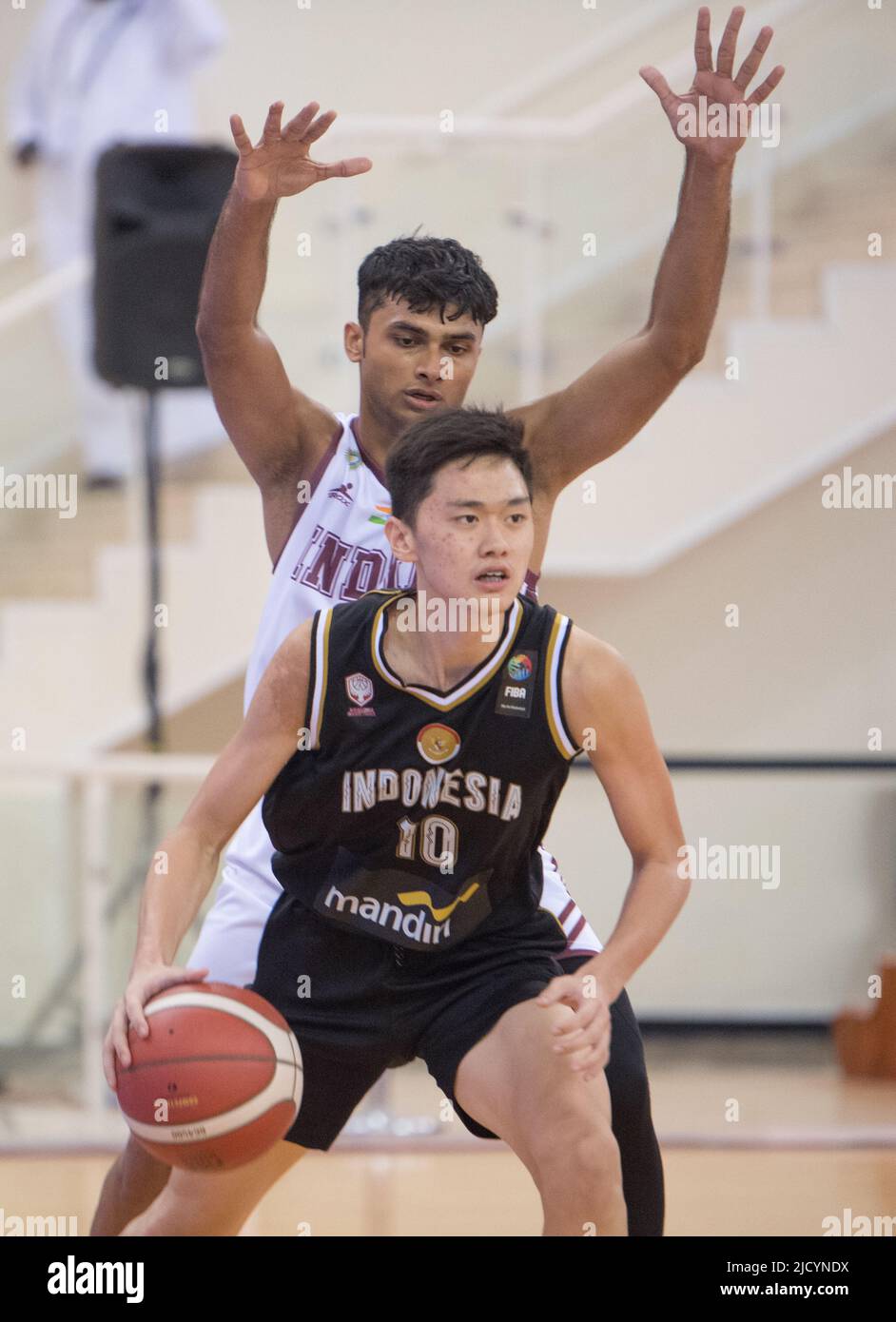 Cliffton Wijaya (front) of Indonesia Basketball team and Harsh Dagar (back) of India Basketball ...
