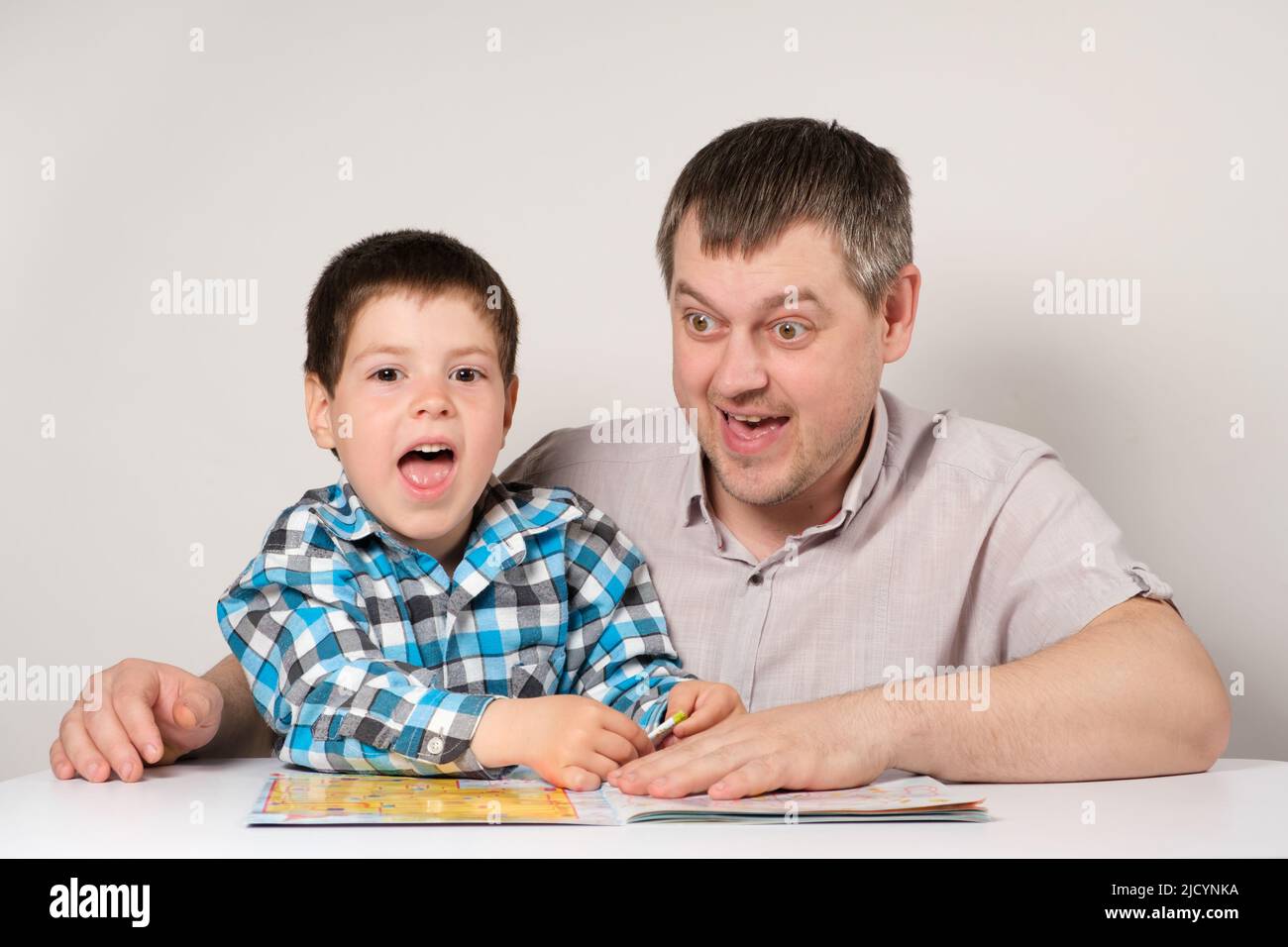 Dad teaches his son to read, names and write letters together. Parent ...