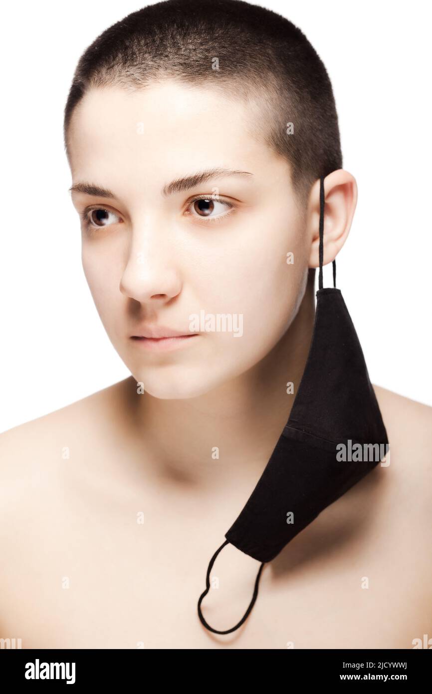 Cute girl with very short hair wearing black protective face mask ...