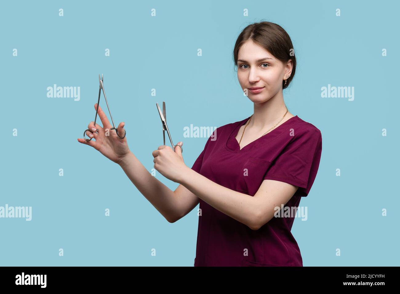 Young Female Surgeon Posing with Steel Surgical Instruments on blue ...