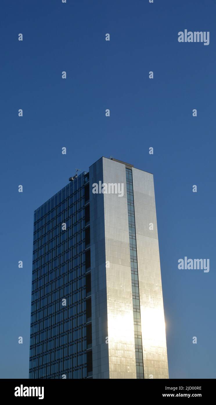 A modern architecture building with a sun reflection on windows and a ...