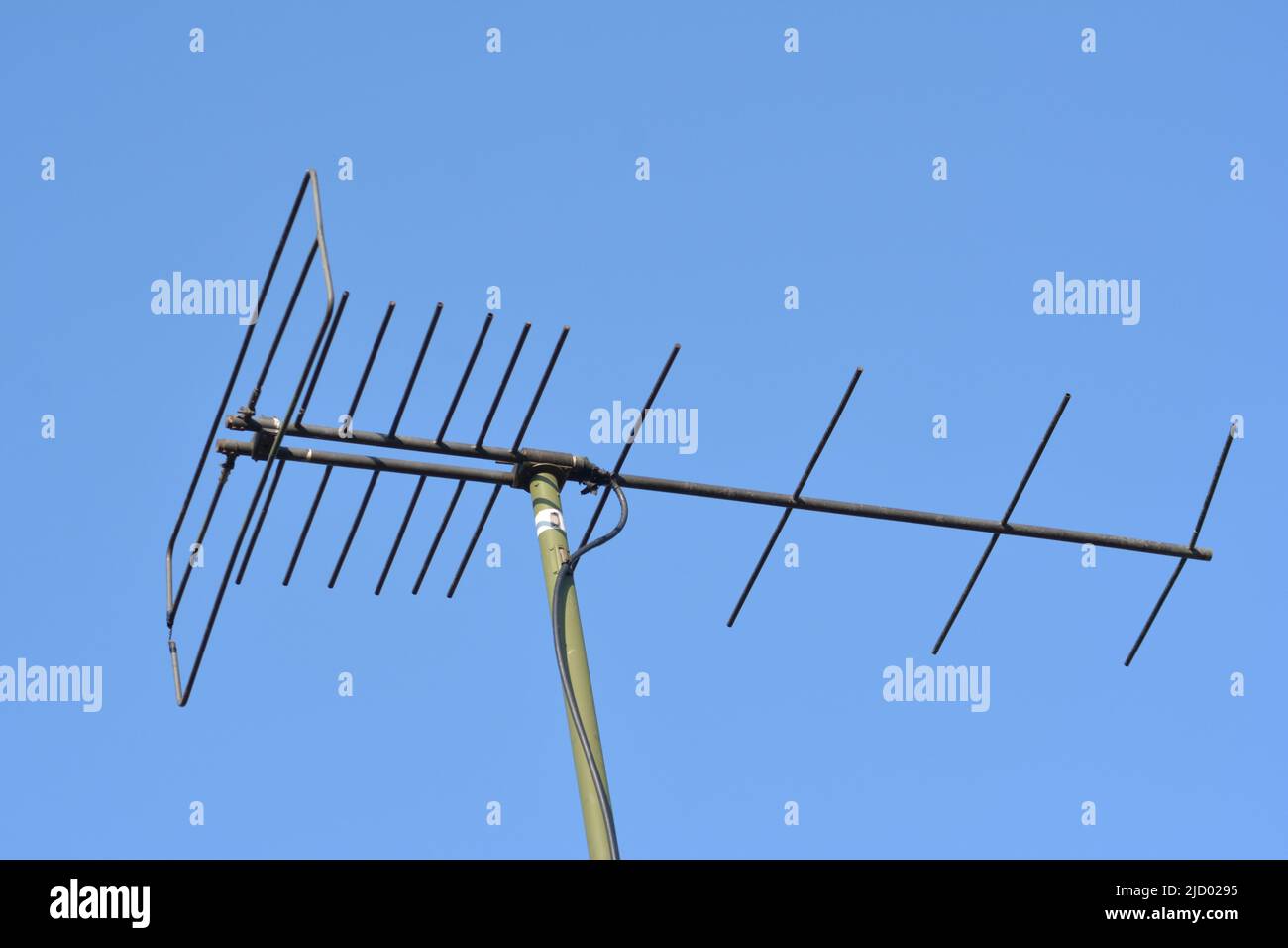 an old antenna on a top of a roof and a blue sky in behind Stock Photo ...
