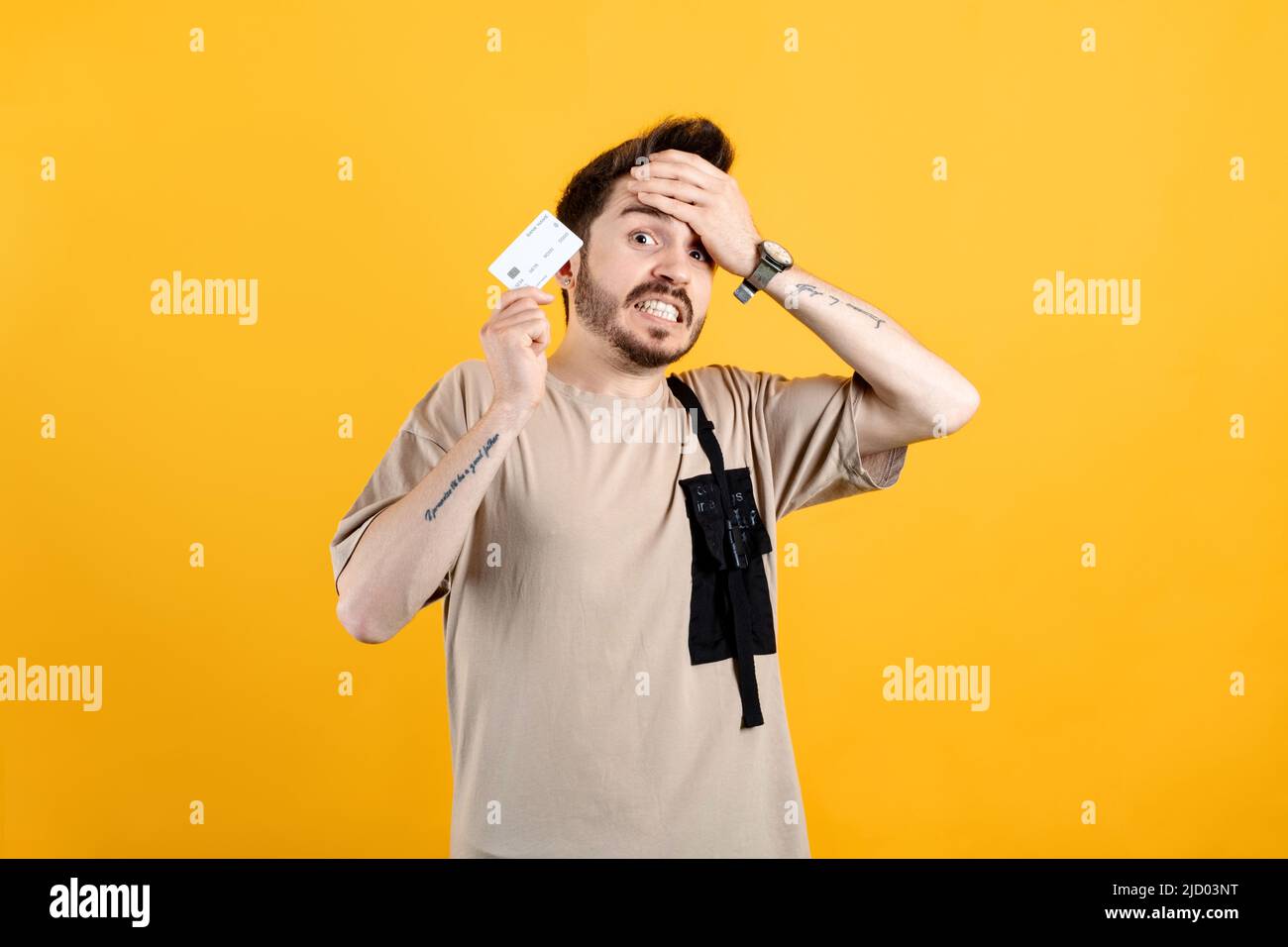 Caucasian man wearing beige tee posing isolated over yellow background ...