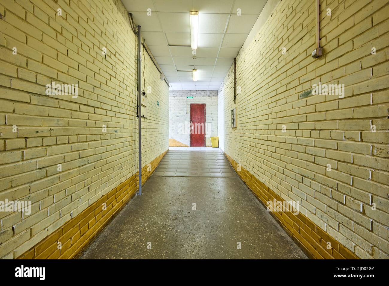 The long beige corridor with brick walls Stock Photo - Alamy