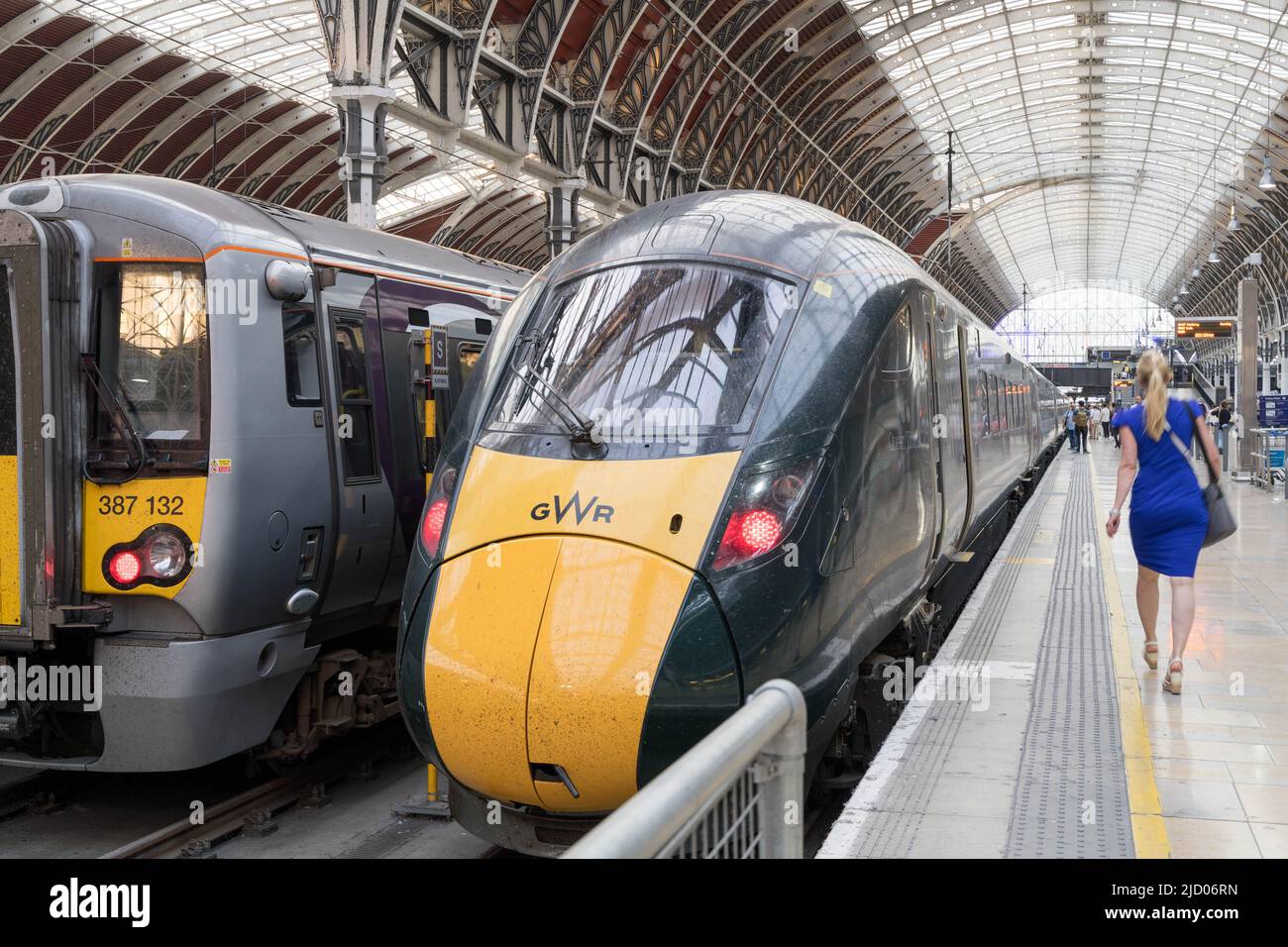 a woman in blue dress carries a shoulder bag boarding GWR train at ...