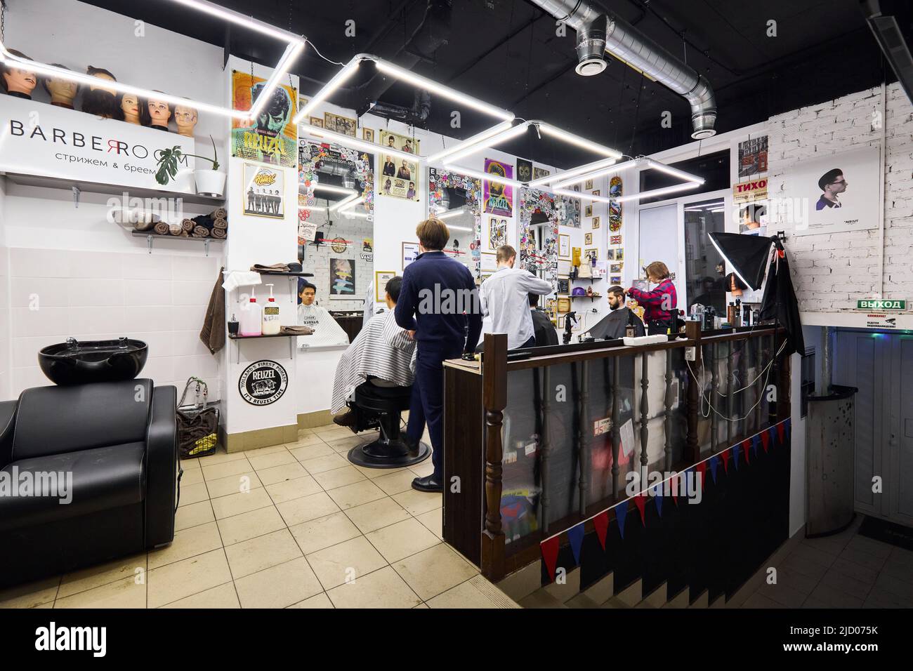 An atmospheric barbershop interior with working employees Stock Photo ...