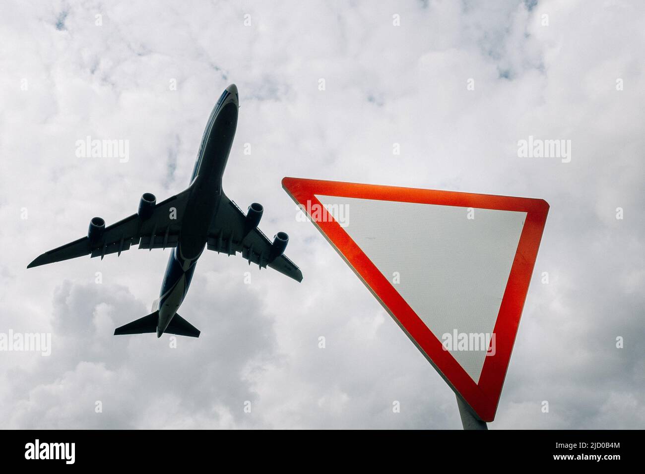 Road sign "Give way" against the background of the silhouette of a ...