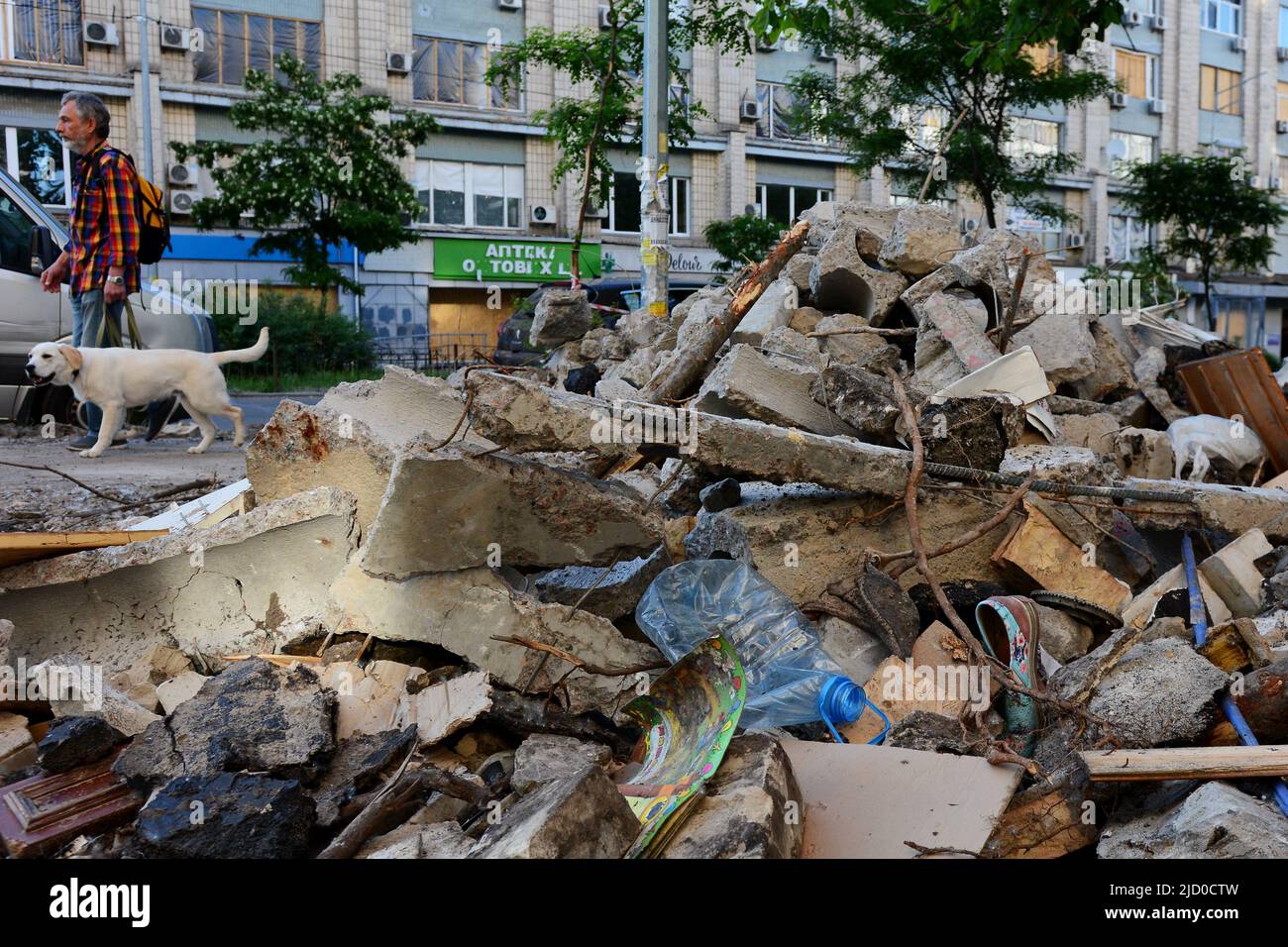 A resident with his dog walks past residential buildings destroyed, by ...