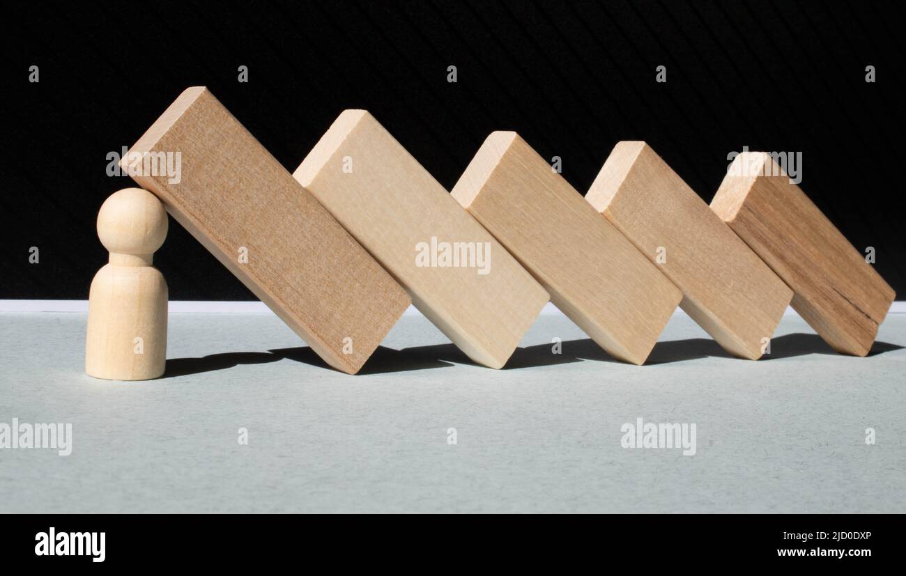 Business man in suit holding with hand falling sequence of wooden ...