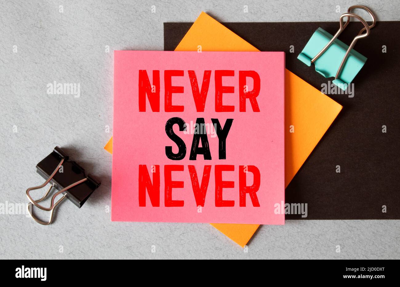 English proverb. an inscription of carved letters on the grass. never say never Stock Photo - Alamy