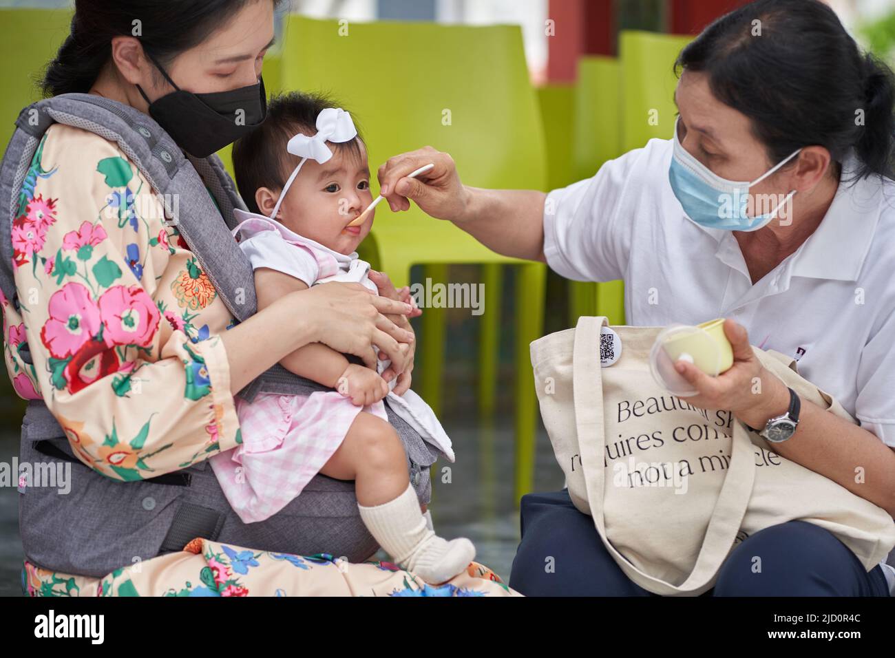 Bangkok, Thailand, february, 16, 2022: two women feeding a baby on the ...
