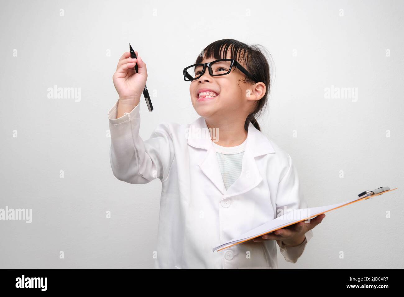 Portrait of a little scientist holding a clipboard with a pen thinking ...