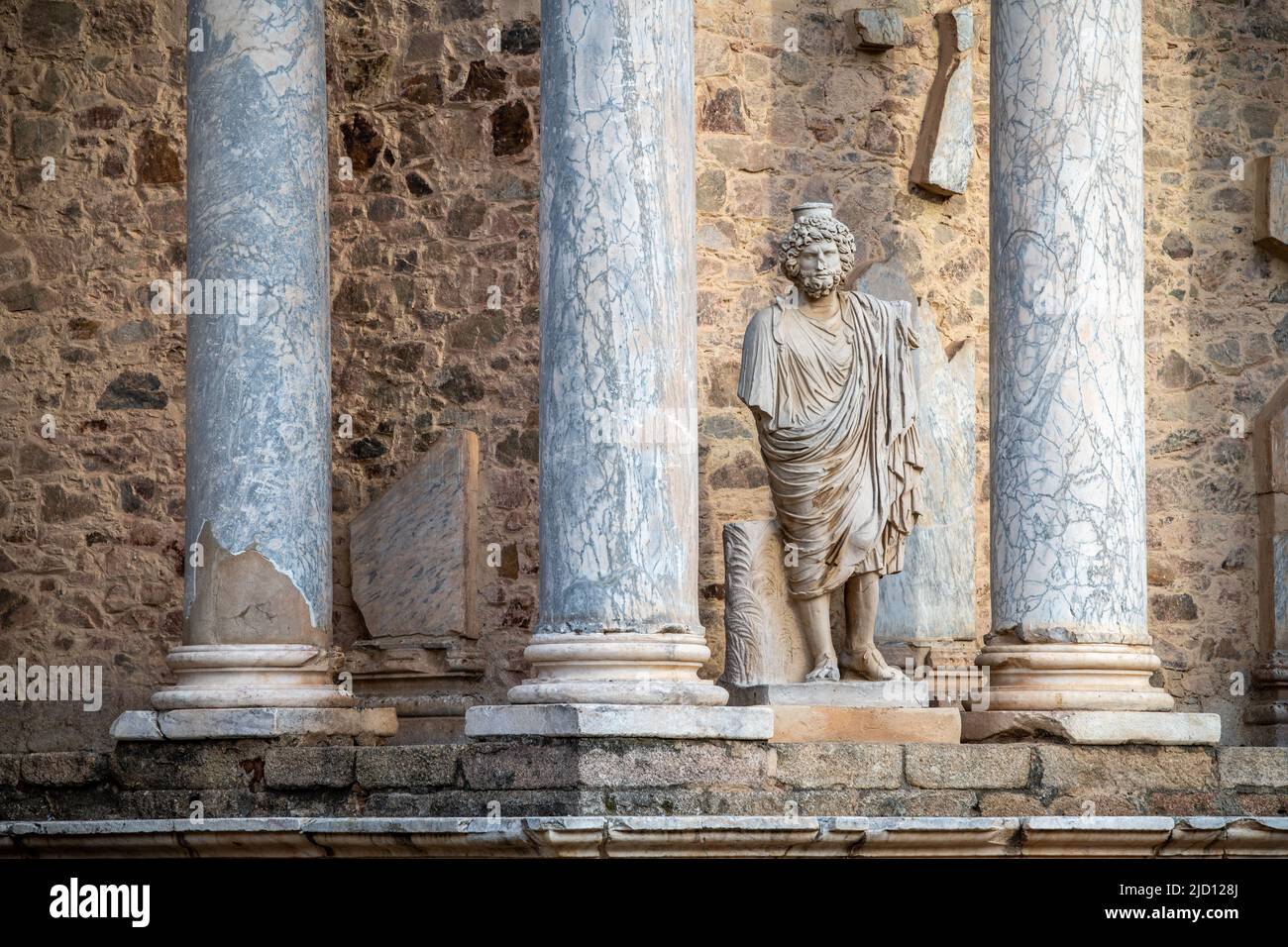 A statue amongst the columns of the Roman Theatre of Merida, Merida ...