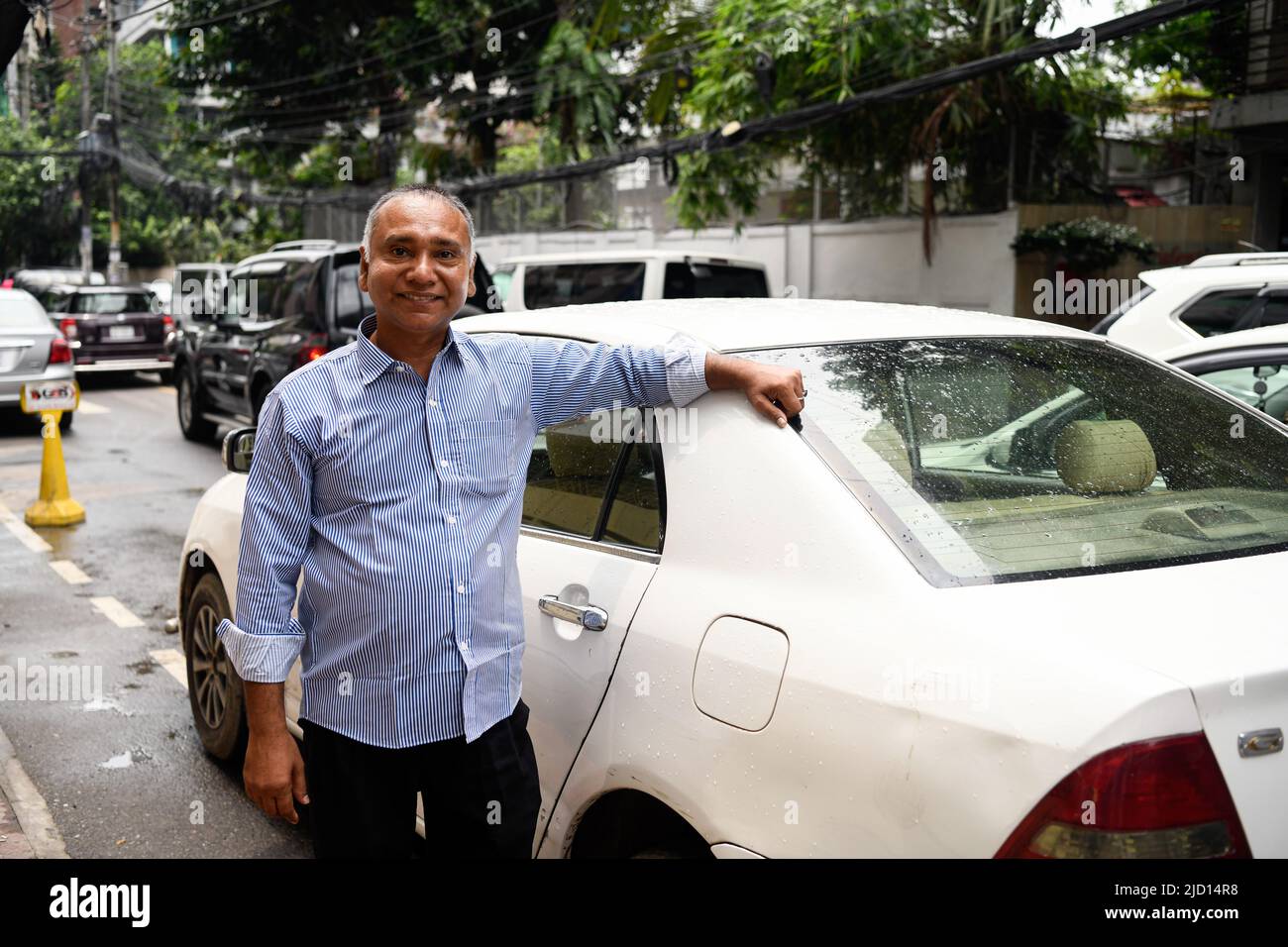 An Uber driver poses for a portrait with his car in Dhaka. (Photo by ...