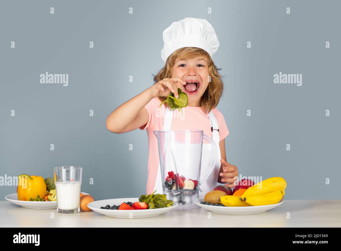 Excited funny chef cook. Child wearing cooker uniform and chef hat hold ...
