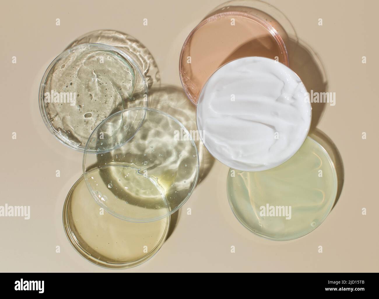 Various cosmetic products in Petri dishes on beige background view from ...
