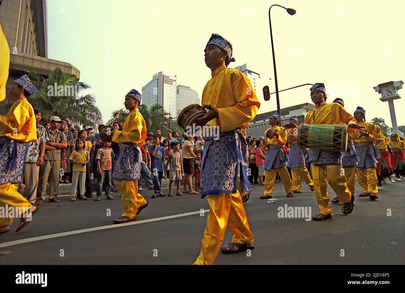 Men wearing traditional attire of Riau playing percussive instruments ...