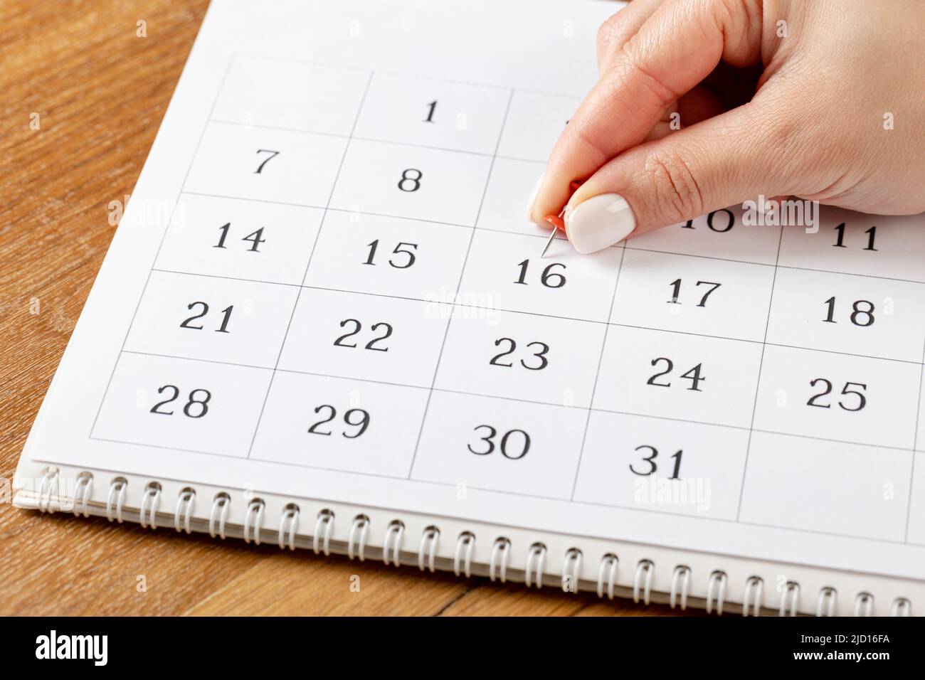 red Hand pin stuck on the day of the month in the calendar, business ...