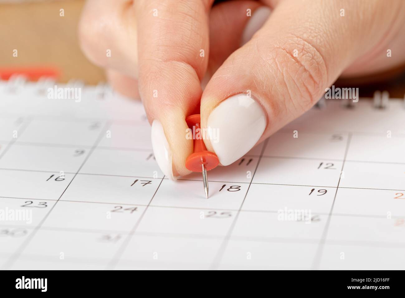 red Hand pin stuck on the day of the month in the calendar, business ...